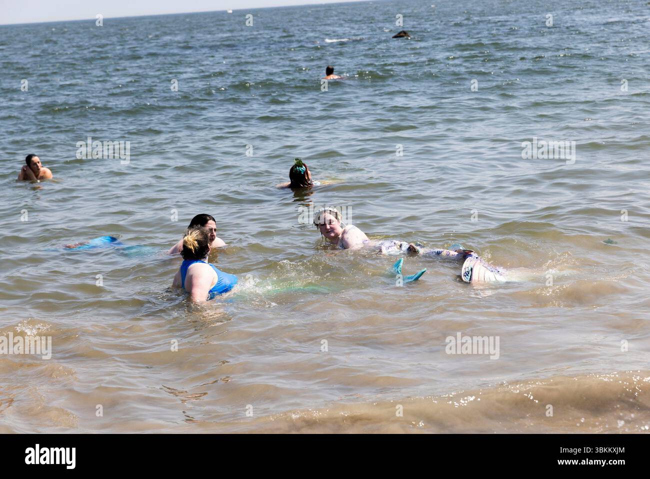 New York, USA. 21st June, 2025. People dressed as mermaids lie in the ...