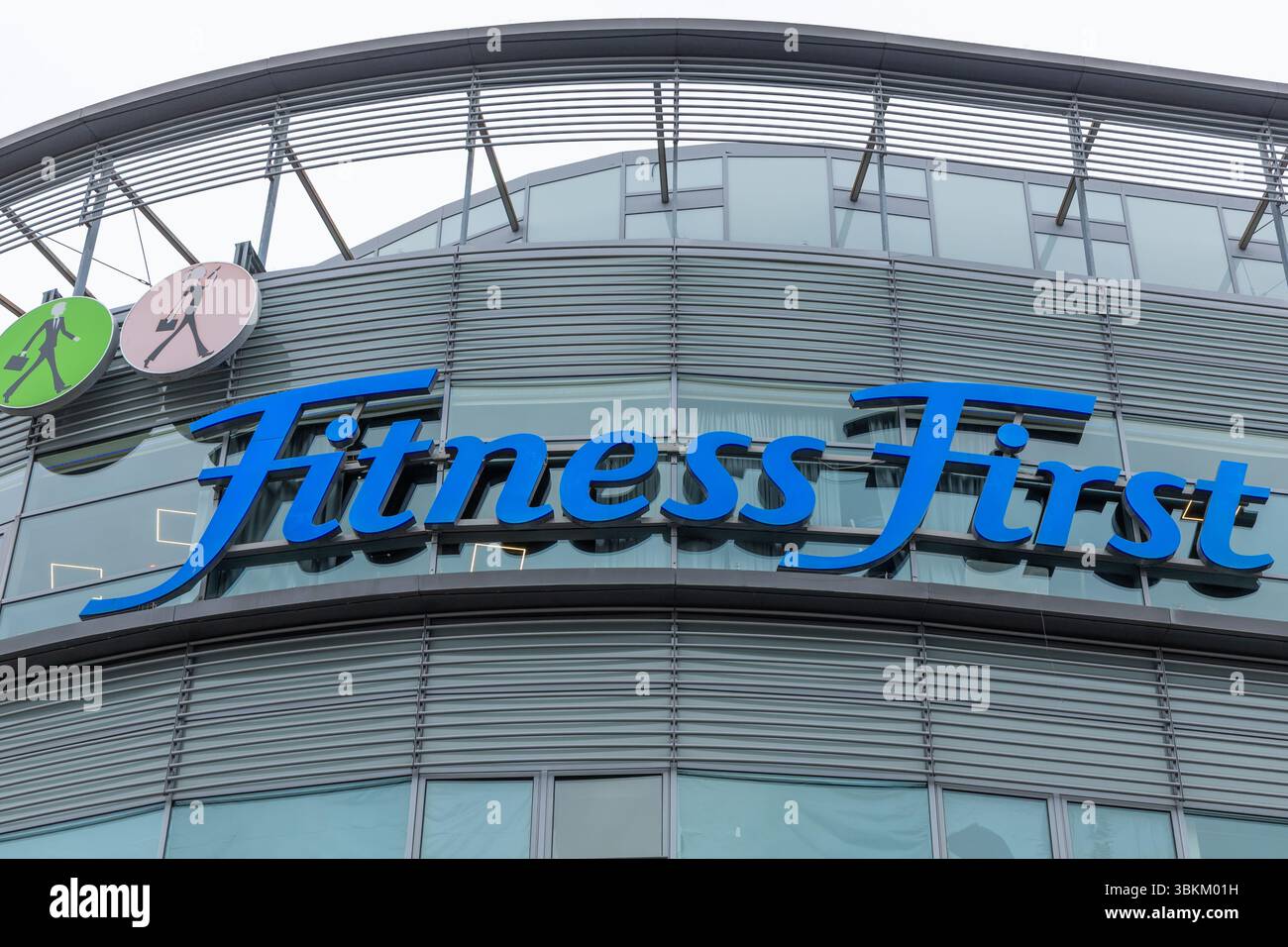 Blue "Fitness First" signage on a modern building with horizontal lines ...