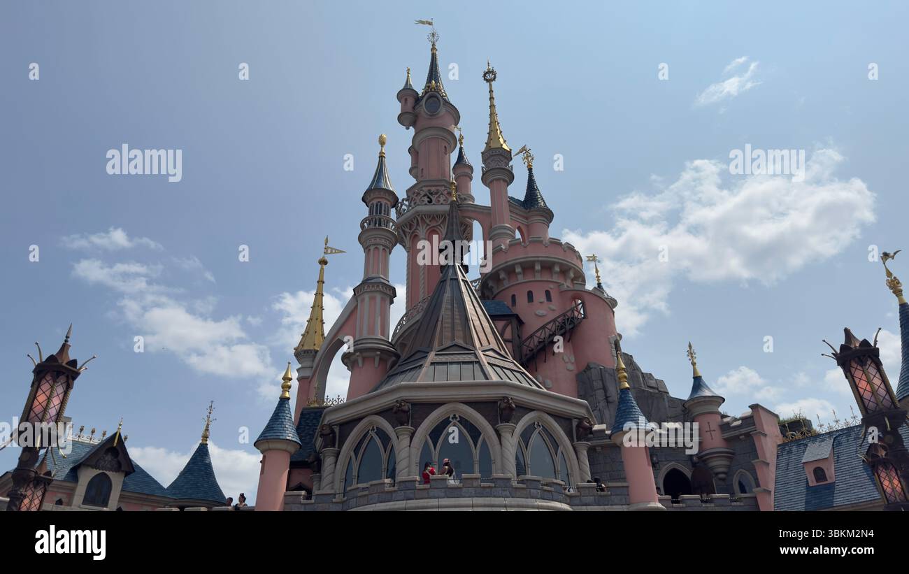 Low-angle view of Sleeping Beauty Castle, featuring its pink and gray ...
