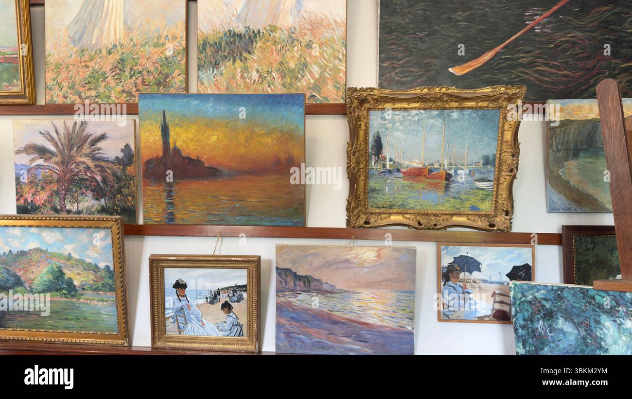 Collection of Impressionist paintings displayed on a wall and shelf ...