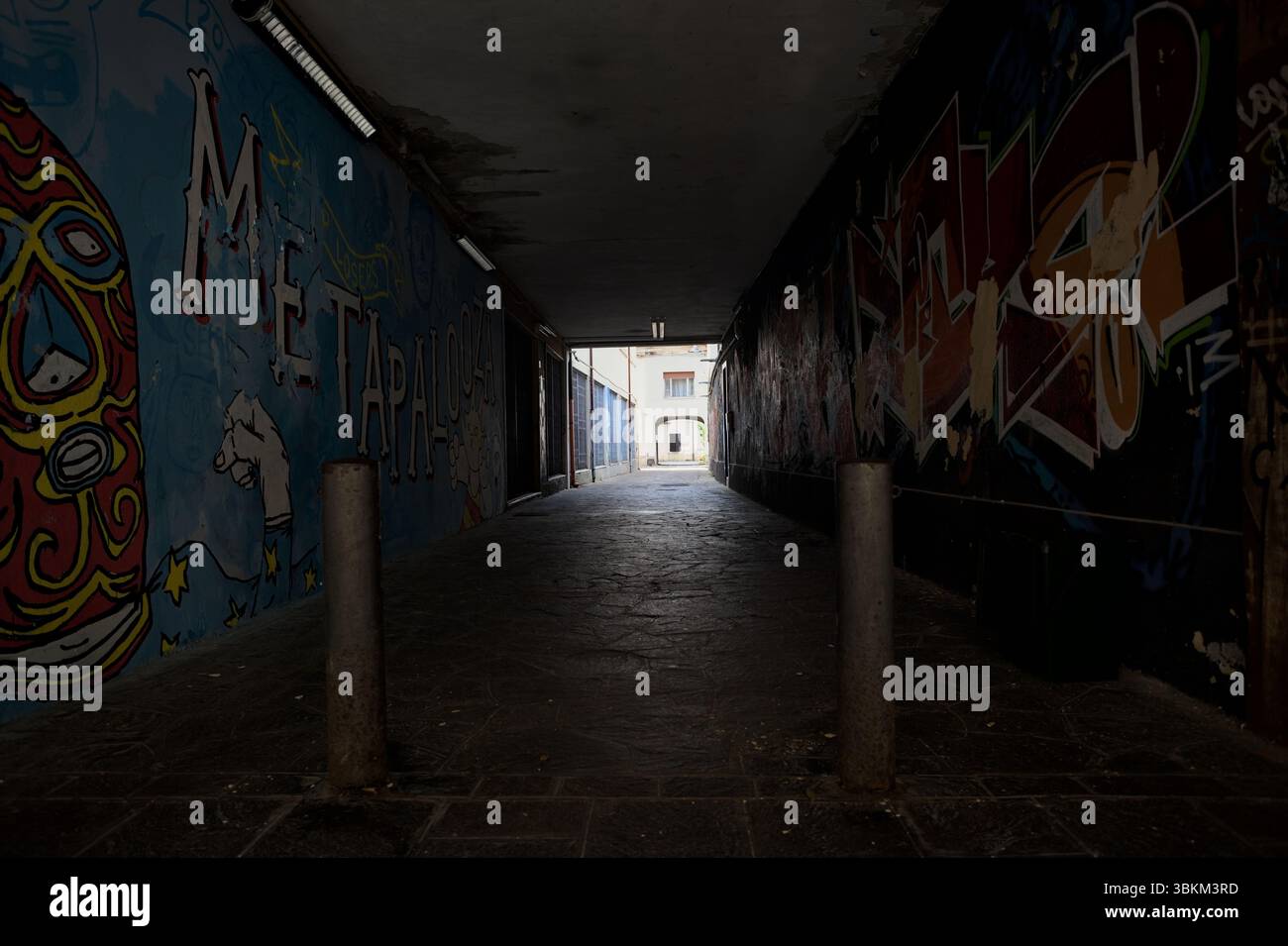 Castel Goffredo, Italy - 17TH JUNE 2025 - Alley under a building with the walls covered by ...