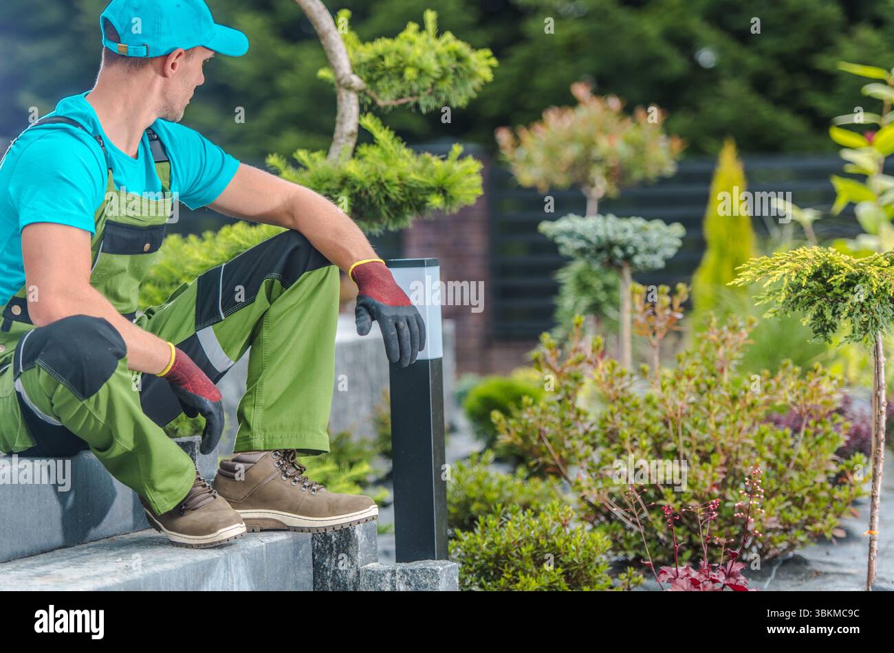 A gardener in colorful work attire takes a break on the steps ...