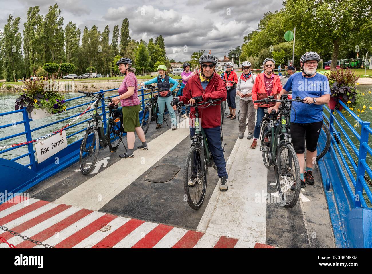 A group of cyclists stand with their bicycles on a ferry in Chaniers ...