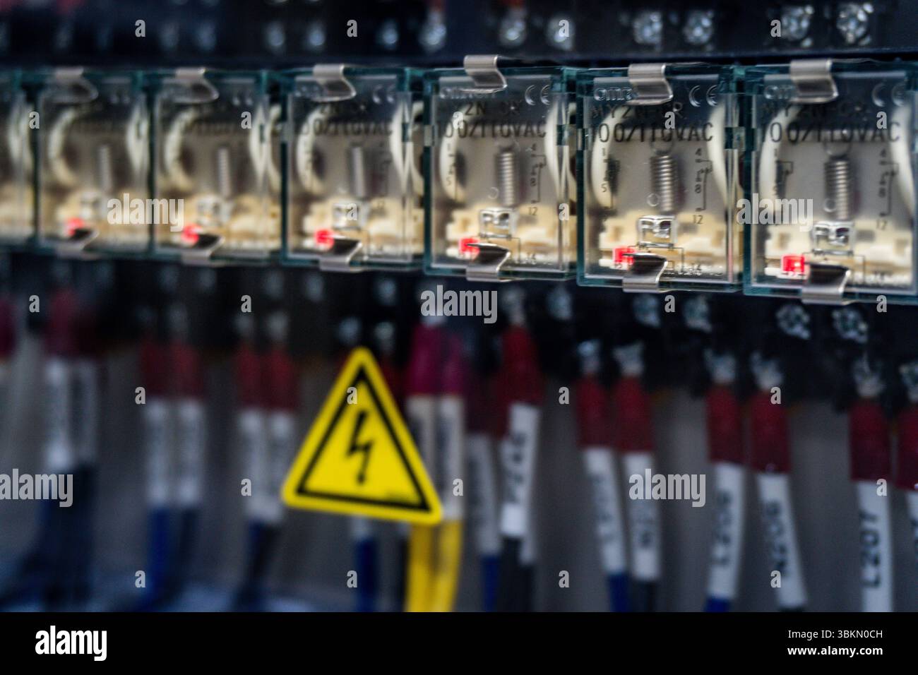Yellow and black warning sign is hanging on a wall. The sign is placed ...