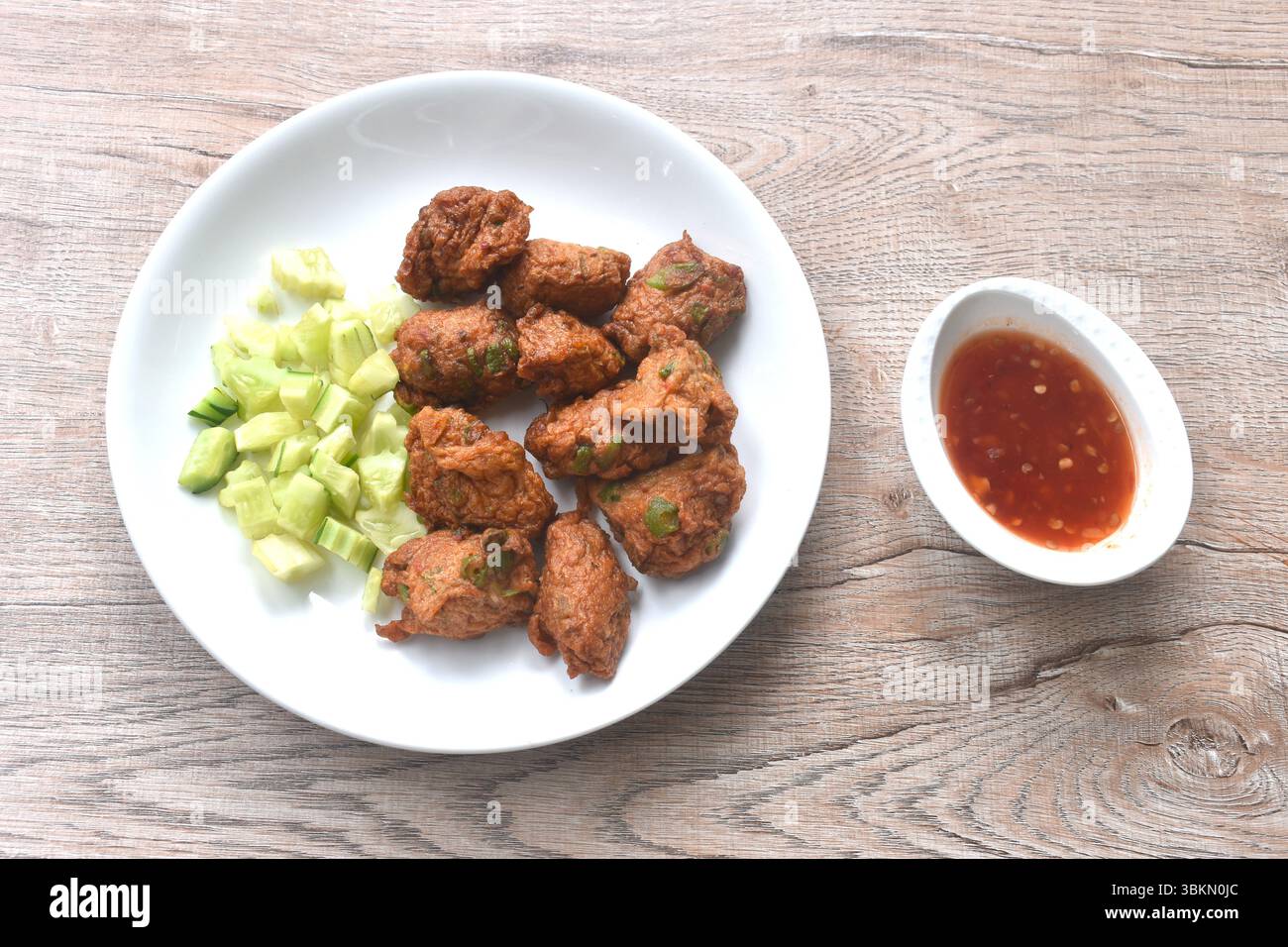 deep fried grouper fish patty on plate with slice cucumber dipping ...