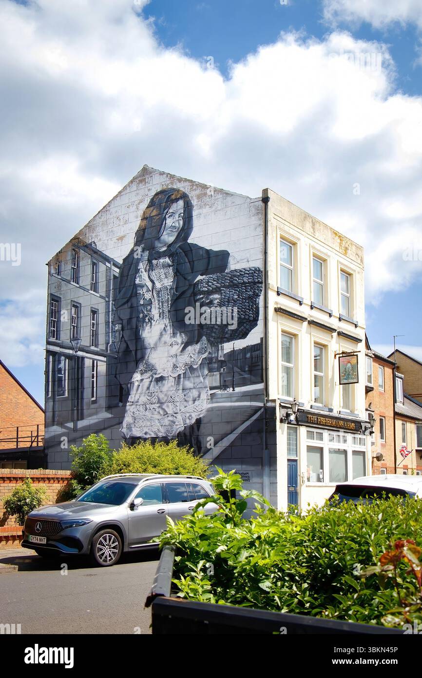 Large mural of a woman in traditional attire painted on the side of the ...