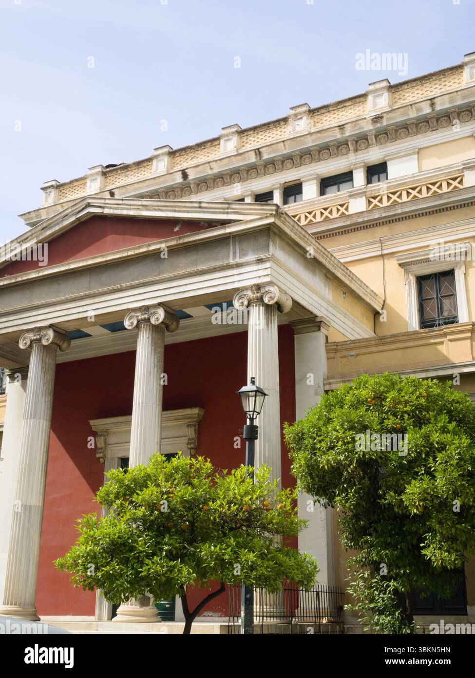 Traditional Greek house with white columns and a red and yellow facade ...