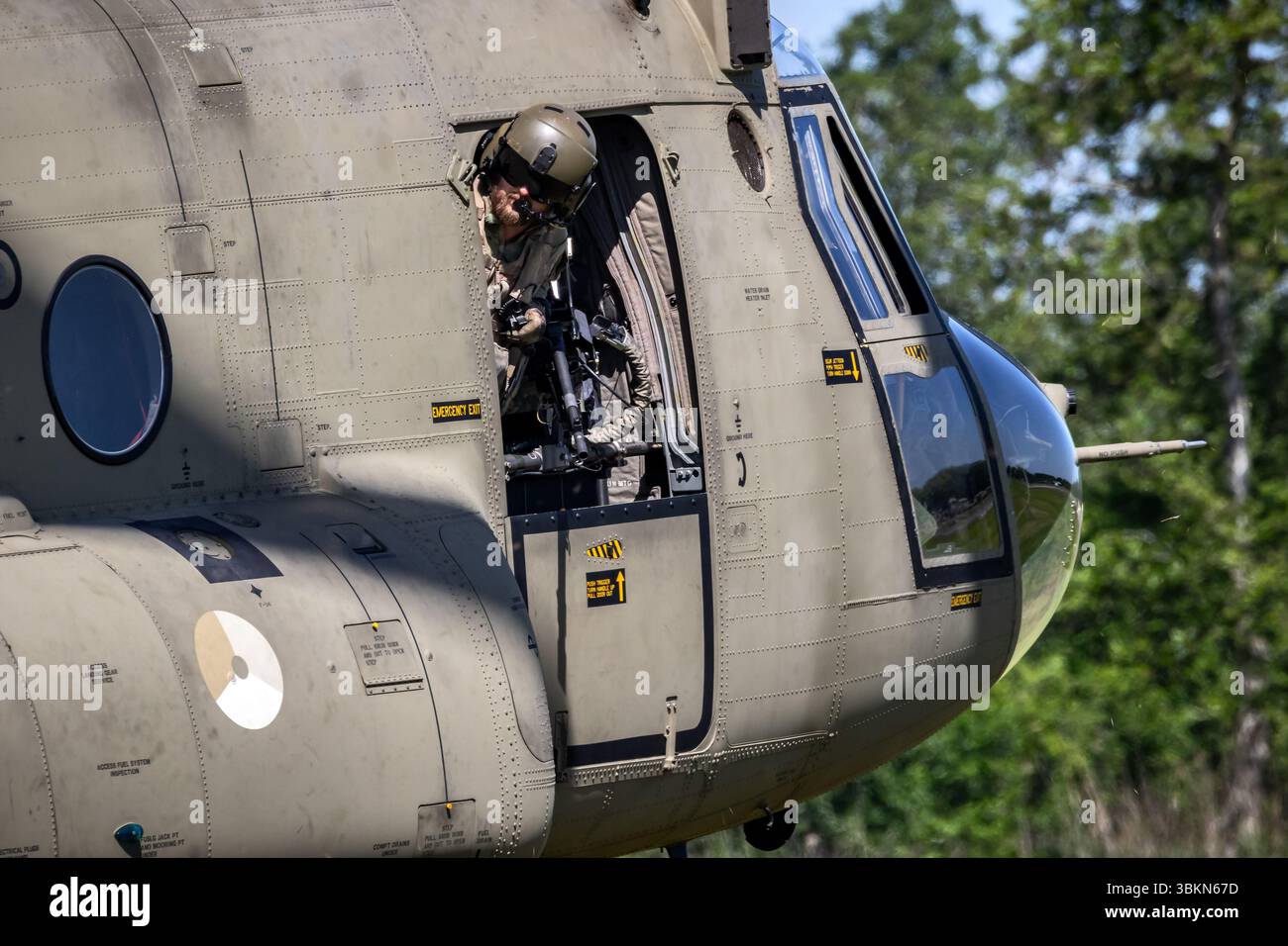 Boeing CH-47F Chinook helicopter crew chief looking out during NATO ...
