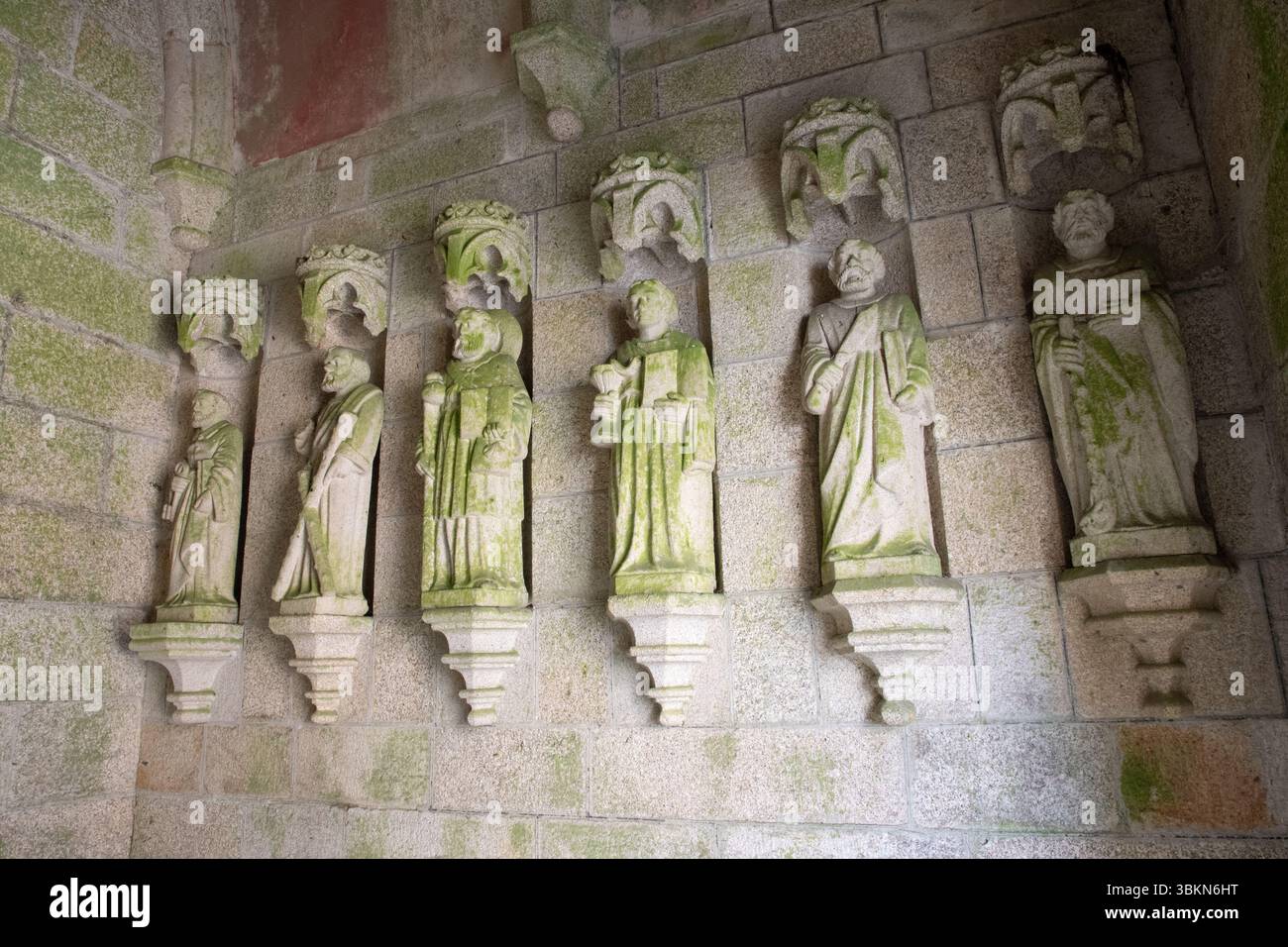 Carved stone figures flanking the entrance to the church of St Pierre ...