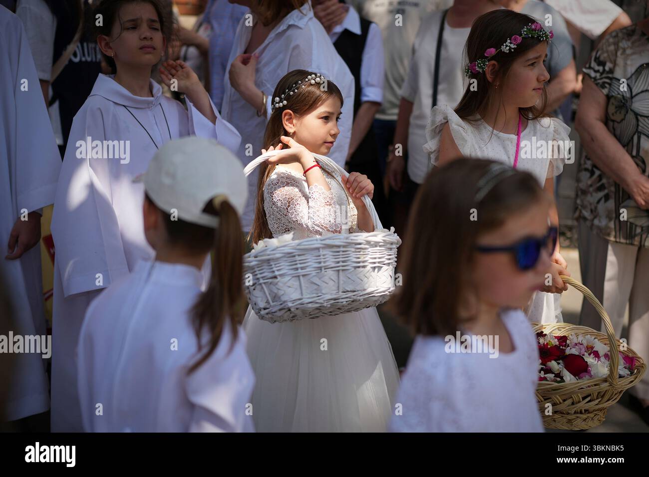Children hold baskets with flower petals as catholic worshipers walk ...