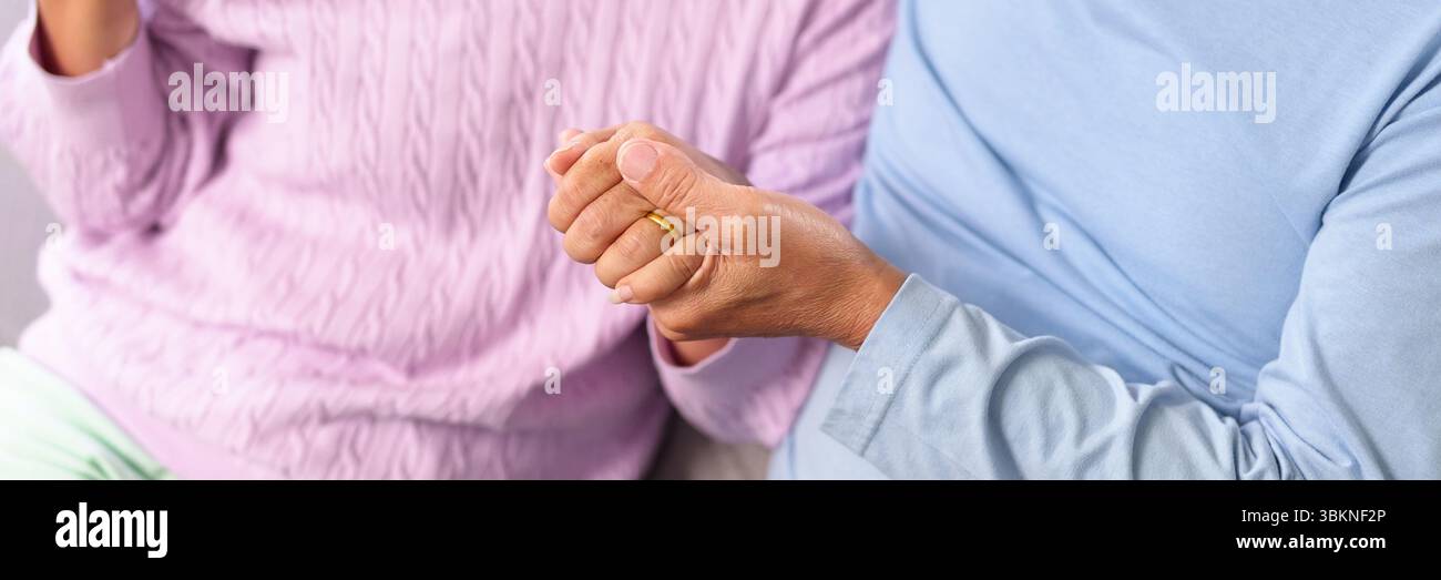 This image shows an older couple holding hands demonstrating enduring ...