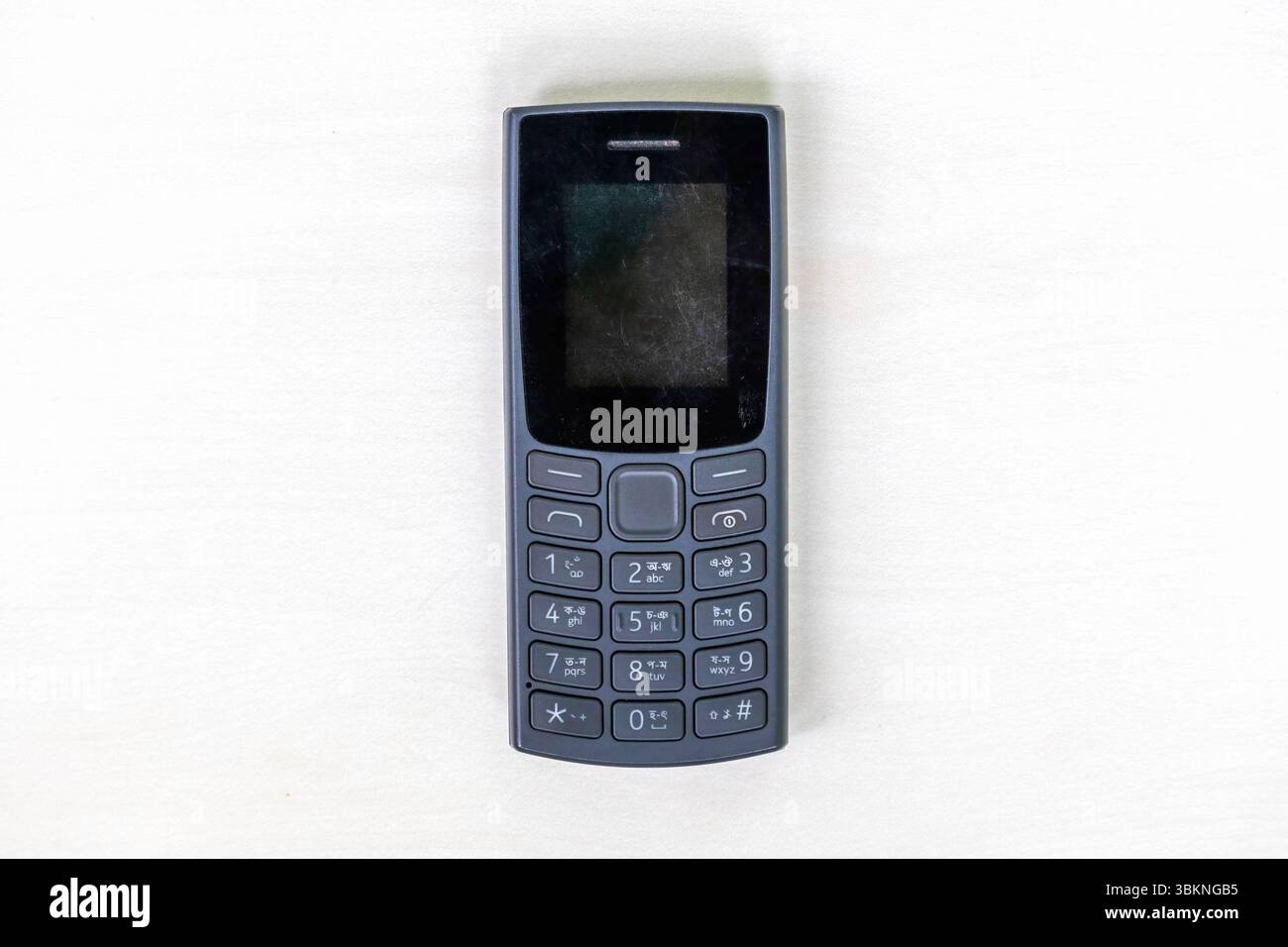 Black button mobile phone, top view. Old used cellular device with ...