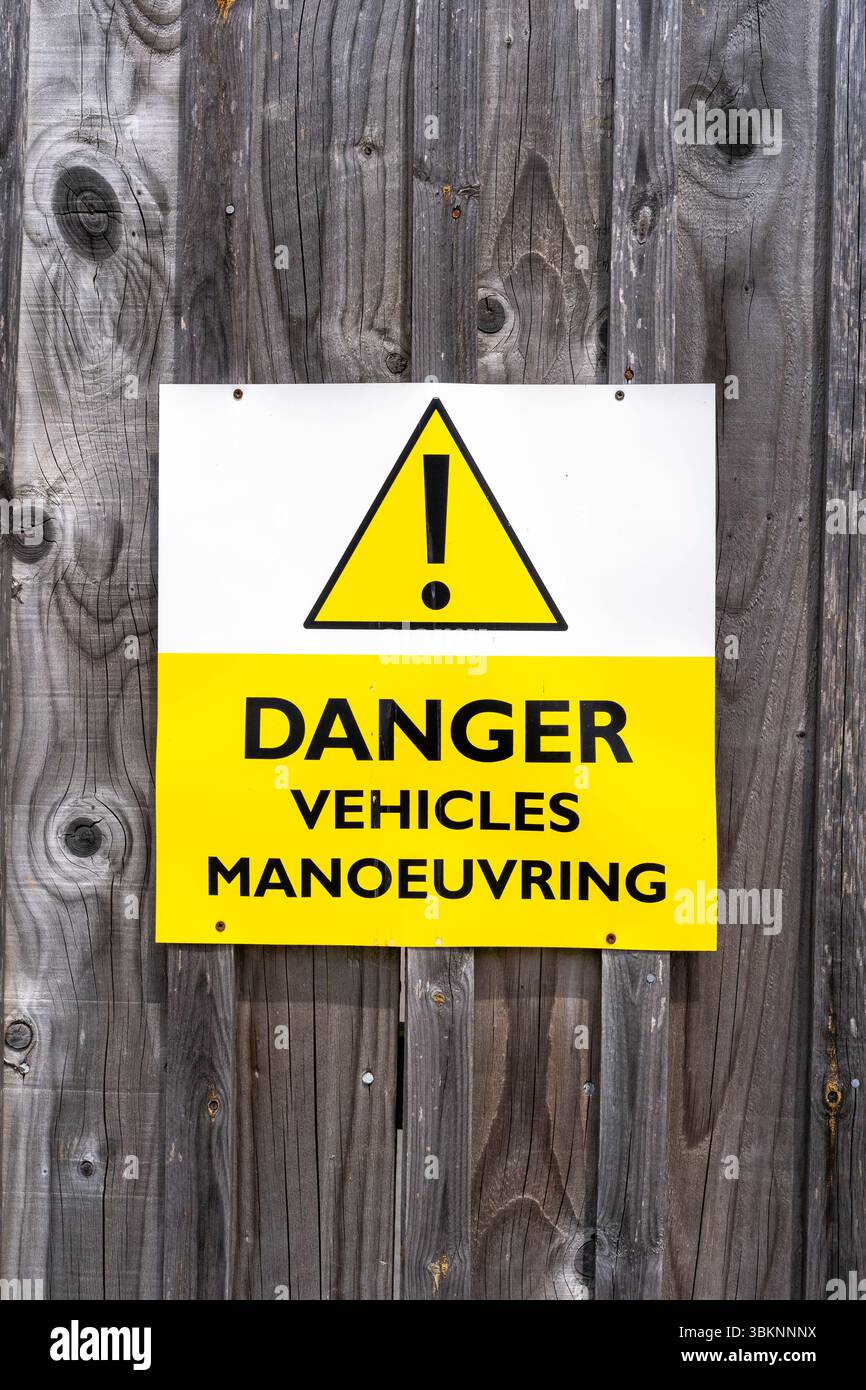 Danger vehicles manoeuvring sign on wood panel fence Stock Photo - Alamy