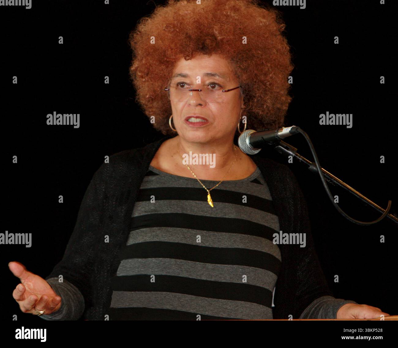 Civil rights icon Angela Davis standing speaks into a microphone ...