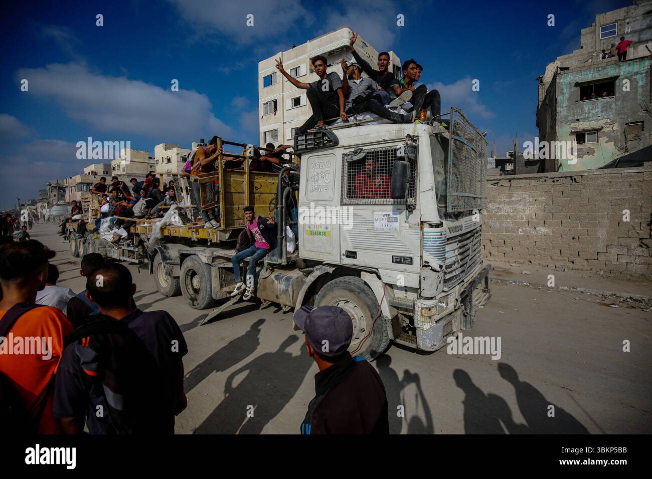 Displaced Palestinians carry relief packages along Rashid Street, west ...