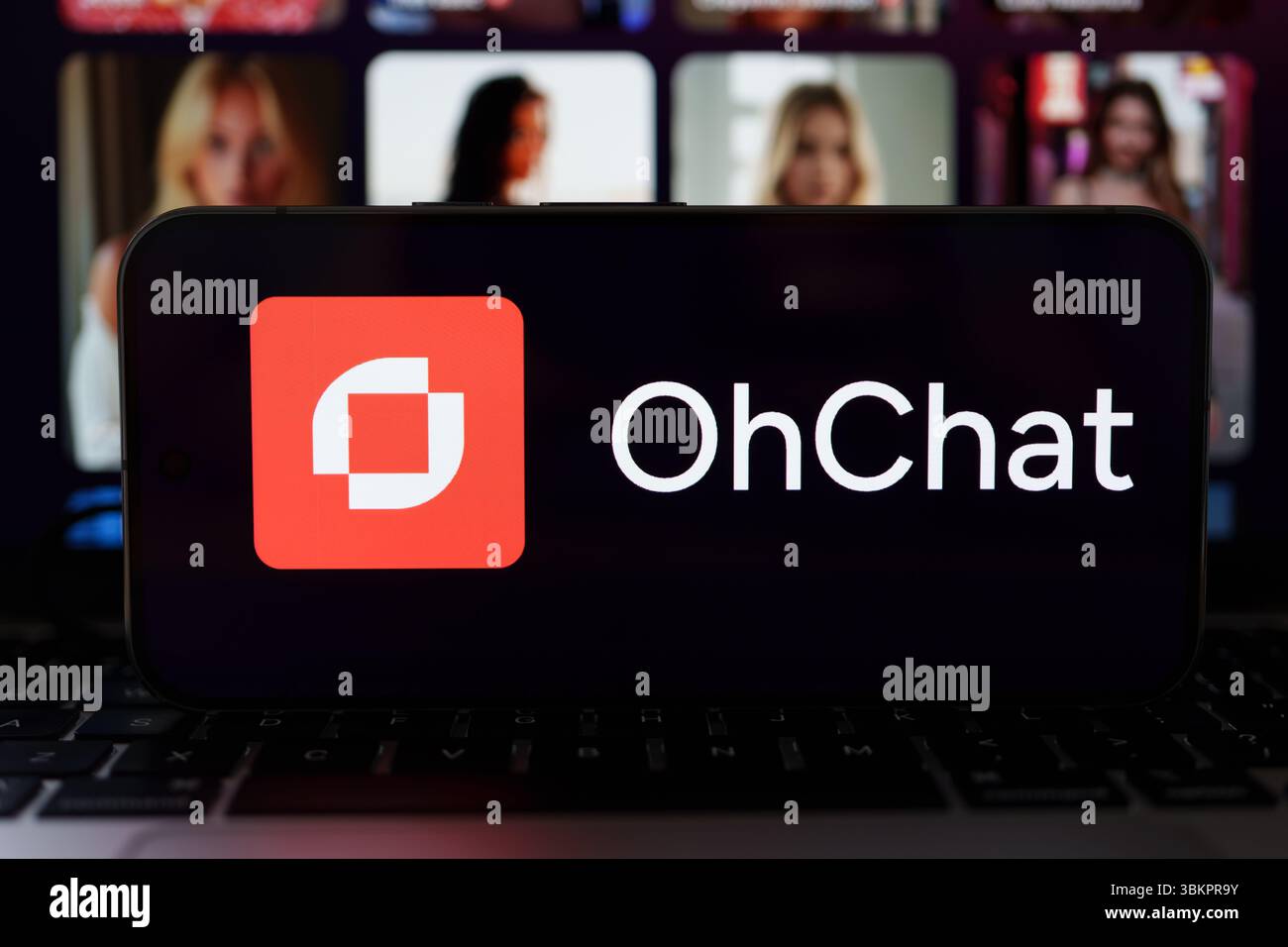 OhChat mobile logo shown on smartphone in front of blurred women in ...