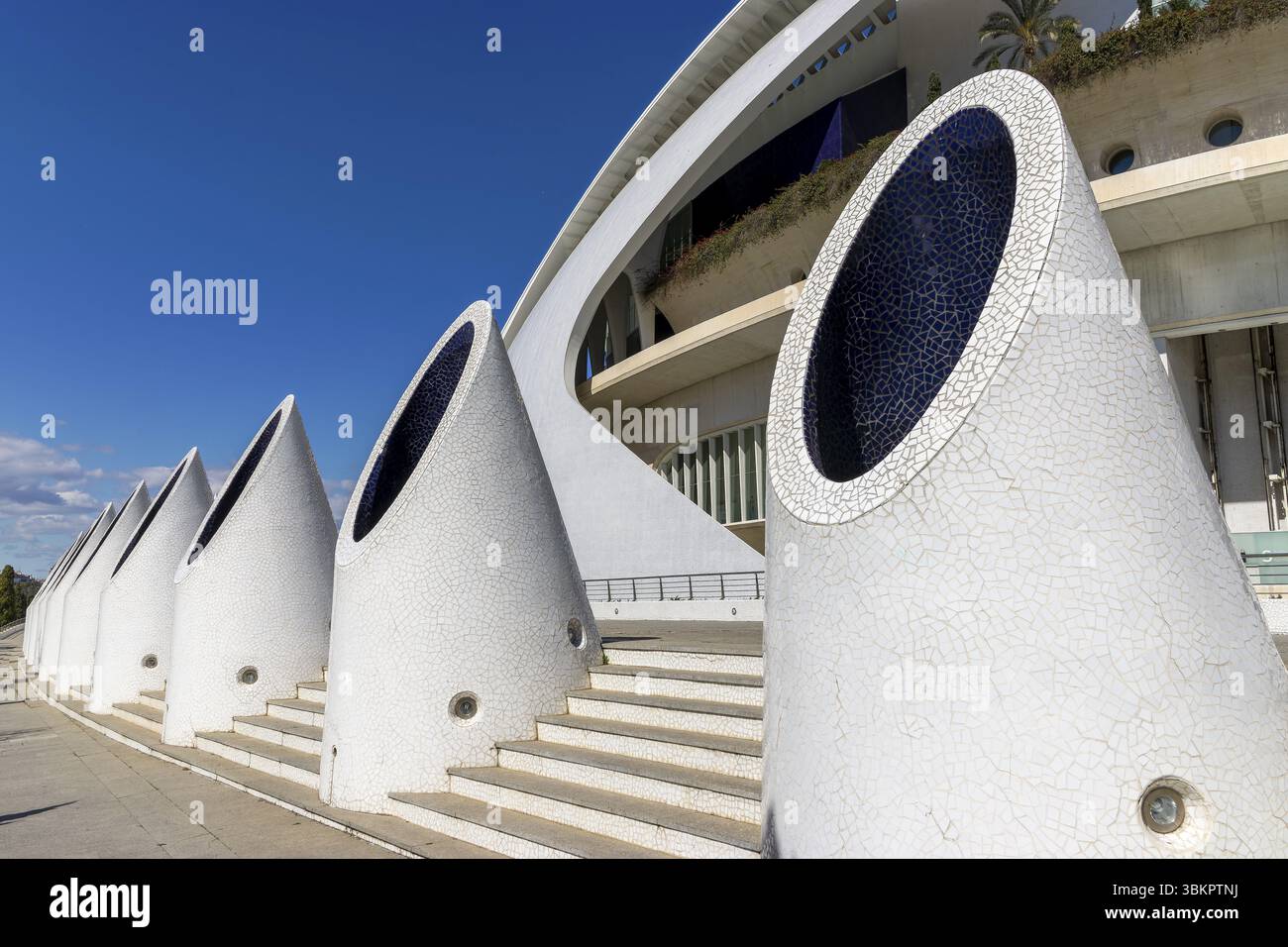 Conical elements lined with white ceramic tiles on the pavement next to ...