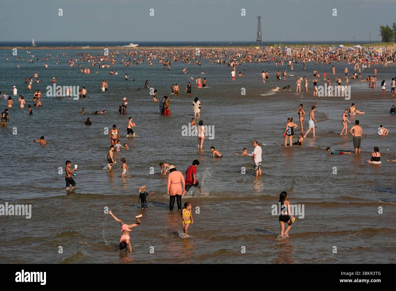 Beach goers crowd a public beach on the Lake Michigan shore, Sunday ...