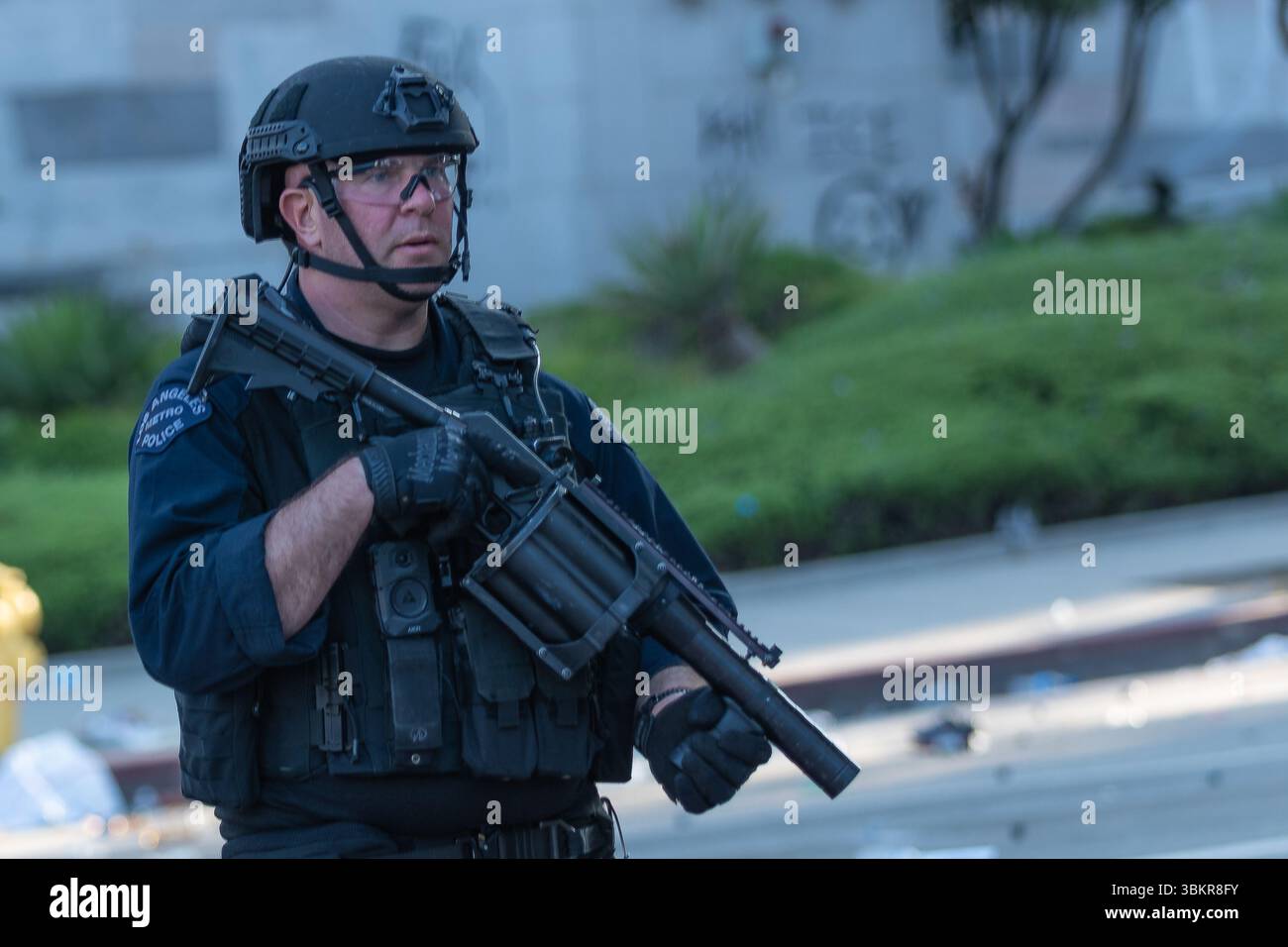 Los Angeles, USA – June 8, 2025: Police officer holding multi-shot less-lethal tactical launcher ...