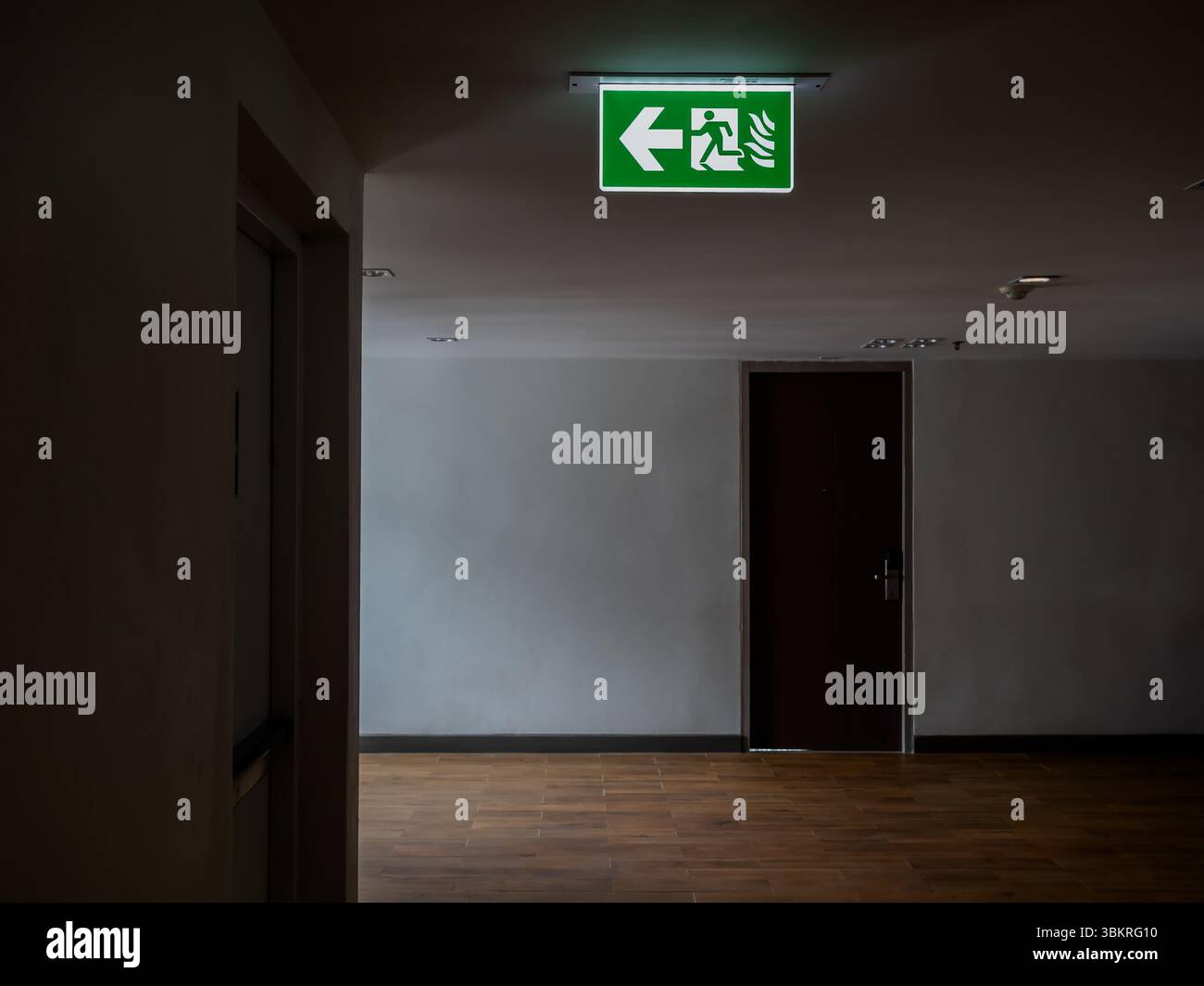 Fire exit sign. Green emergency exit sign hanging from ceiling glowing ...