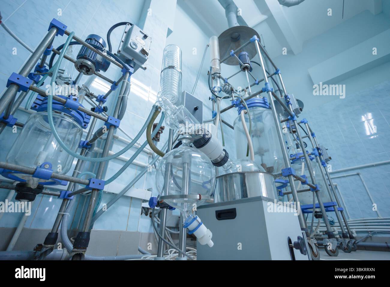 Industrial lab with large glass reactors and distillation equipment for ...