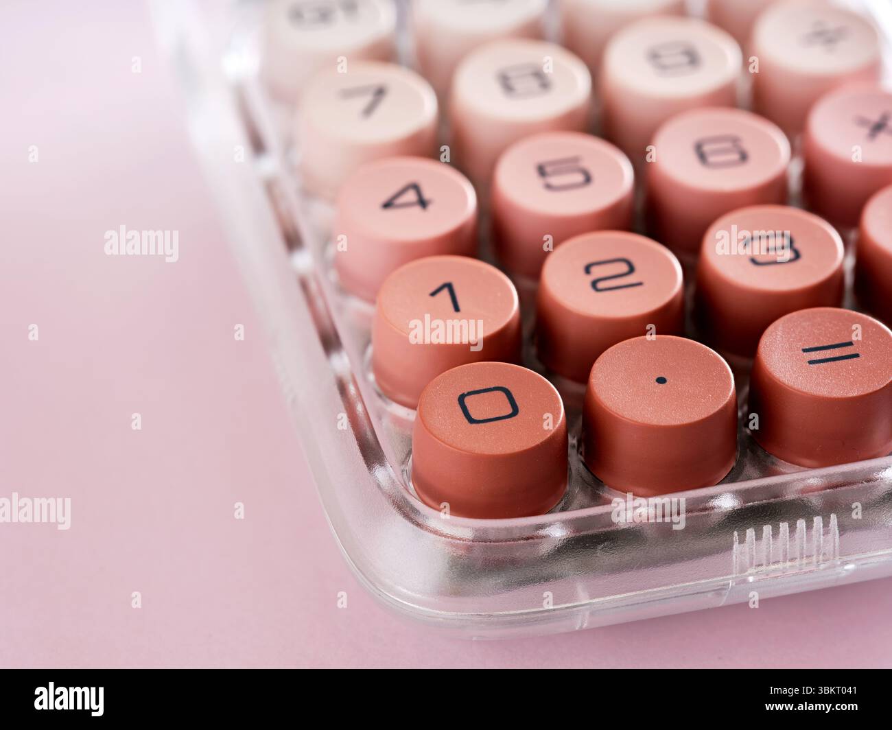 Close-up of a modern calculator with round pink keys, showcasing its ...