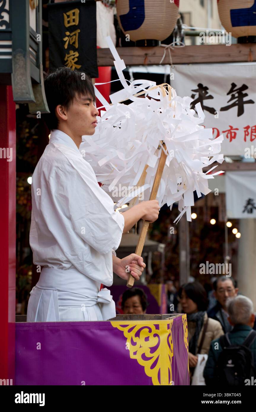 Tori-no-Ichi November event at Otori Jinja Shinto shrine. Believers are blessed with "onusa ...