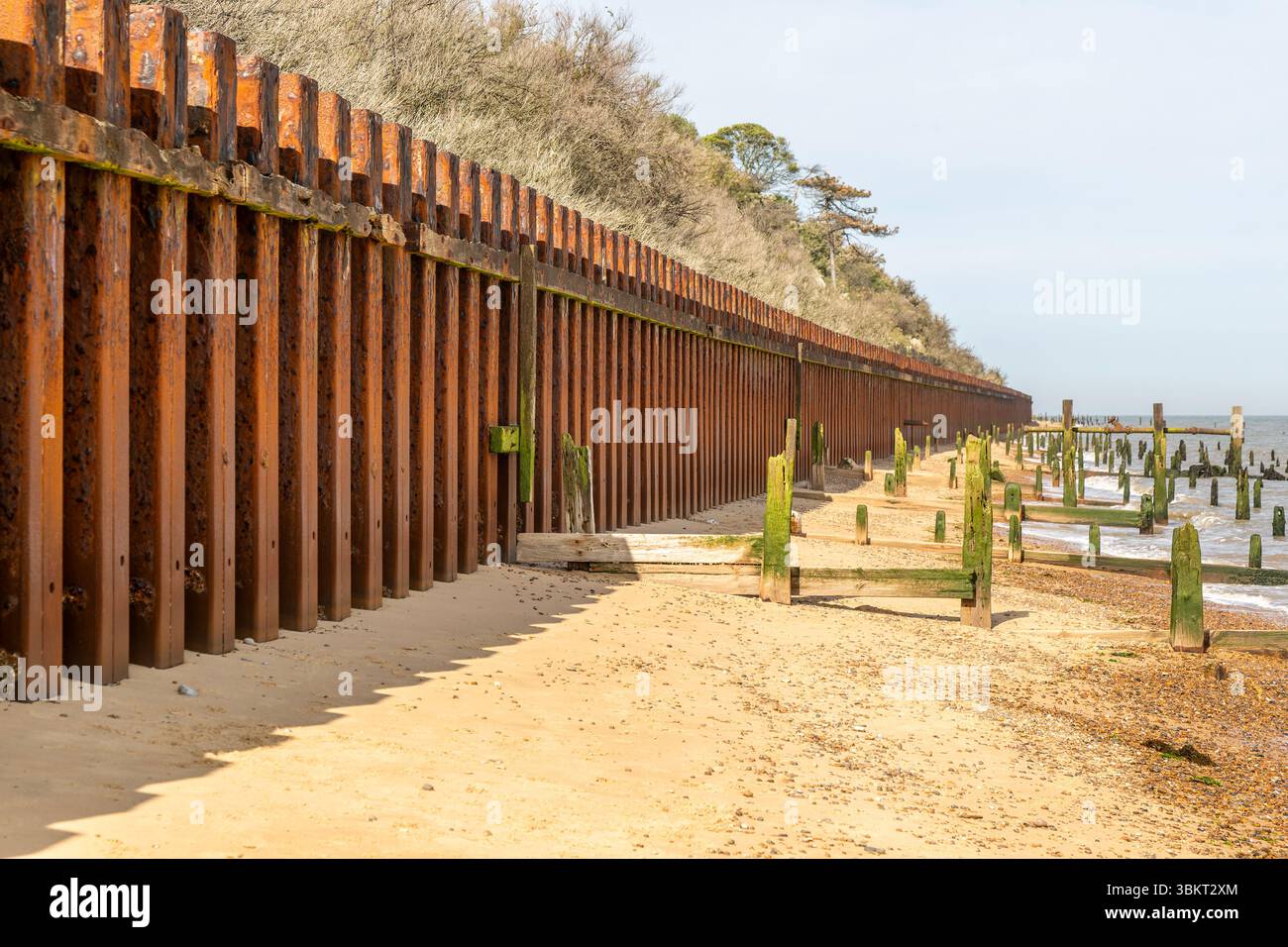 Steel sheet piling sea wall old broken wooden groynes coastal defences ...