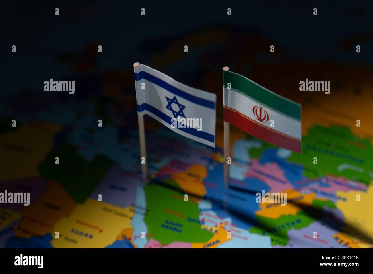 Miniature flags of Israel and Iran are planted on a blurred map ...