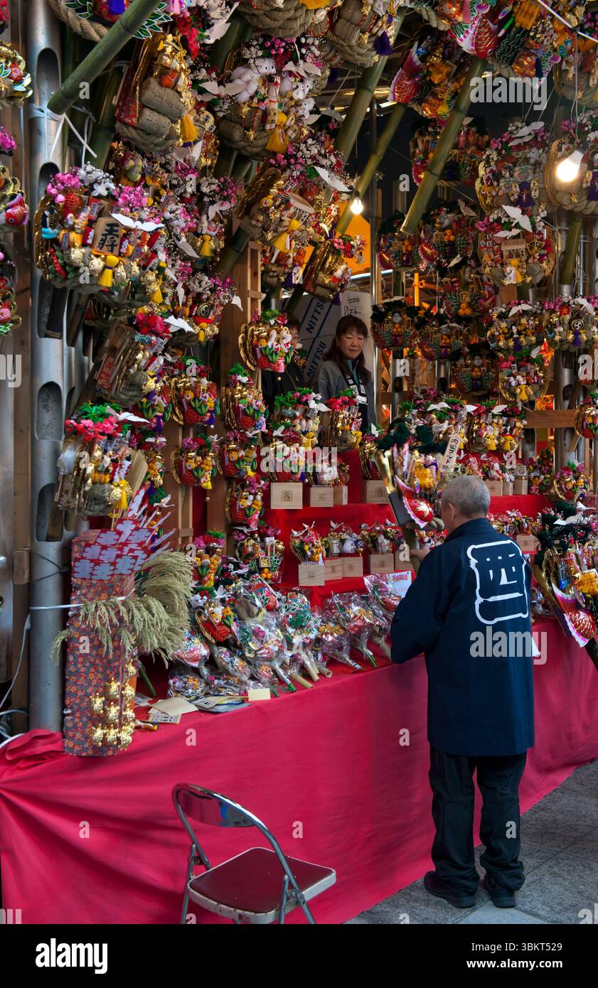 Tori-no-Ichi November event at Otori Jinja Shinto shrine. Believers purchase elaborate New Year ...