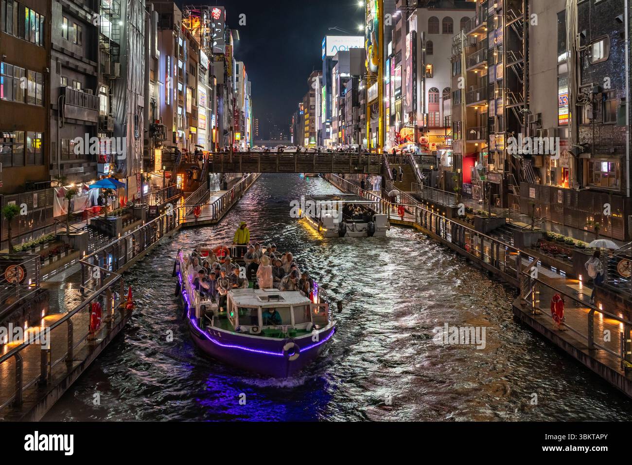 Tourist boats on Dotonbori canal on a wet night. Dotonbori is a ...