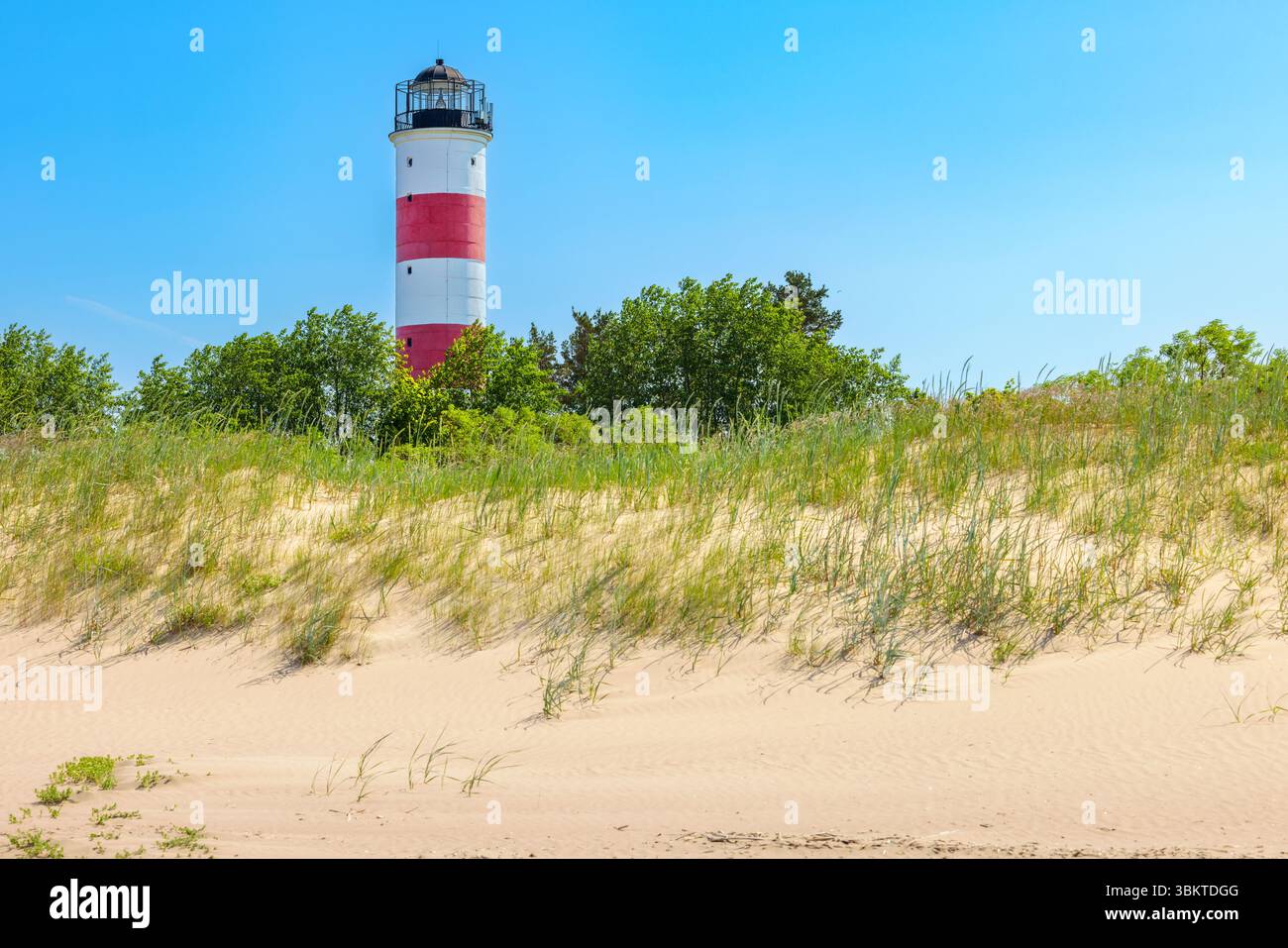 Old lighthouse rises above sand dunes of beach in Narva-Jõesuu. Estonia ...
