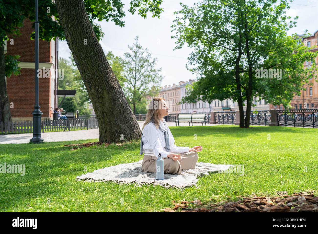 Female sit cross legged on blanket in park, practicing mindfulness ...