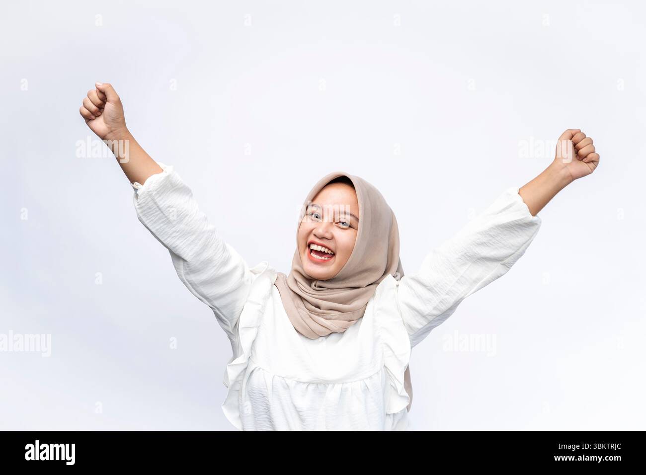 Excited beautiful Indonesian Muslim woman wearing hijab celebrating ...
