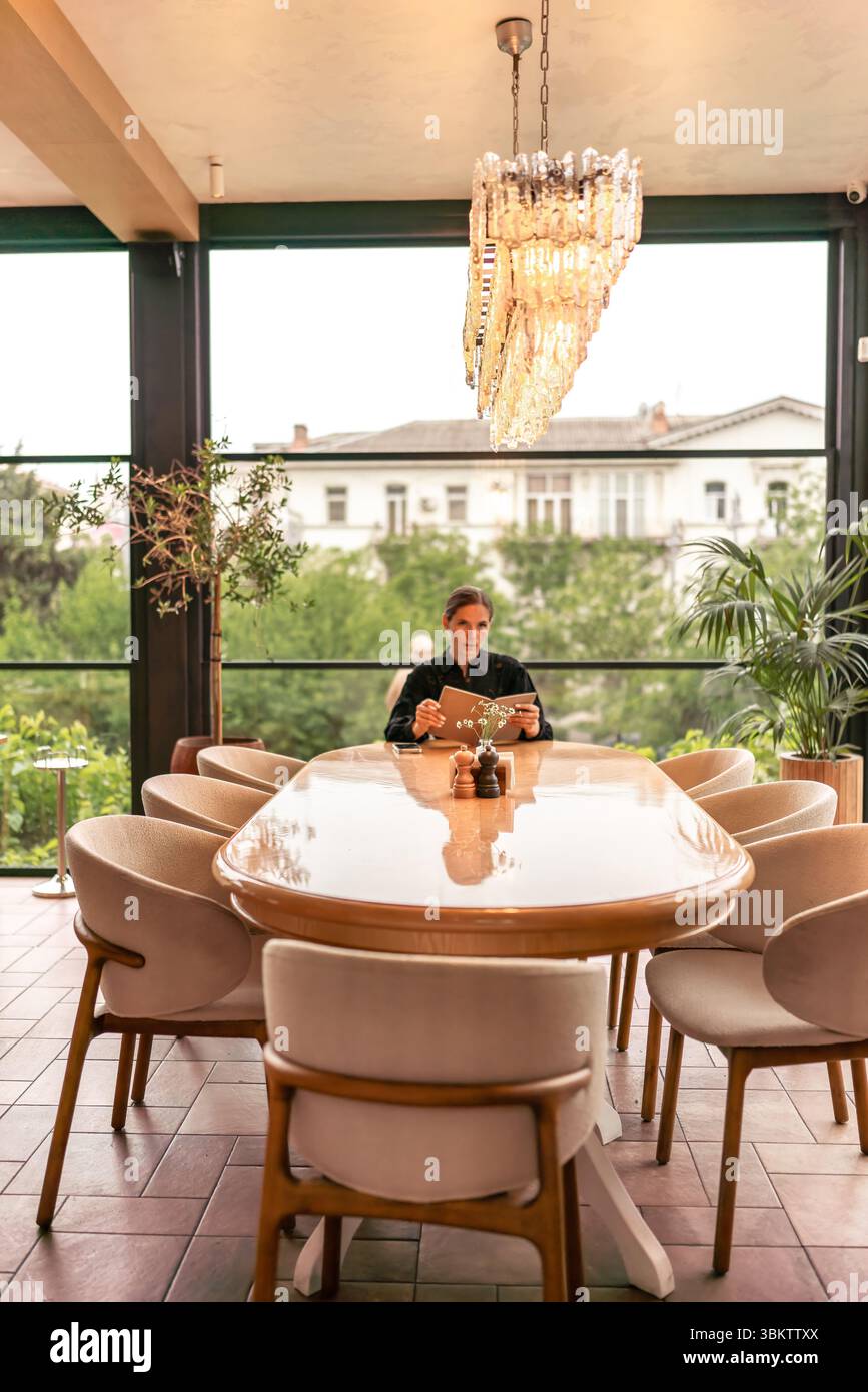Restaurant menu chandelier: Woman reads menu in luxury restaurant in ...