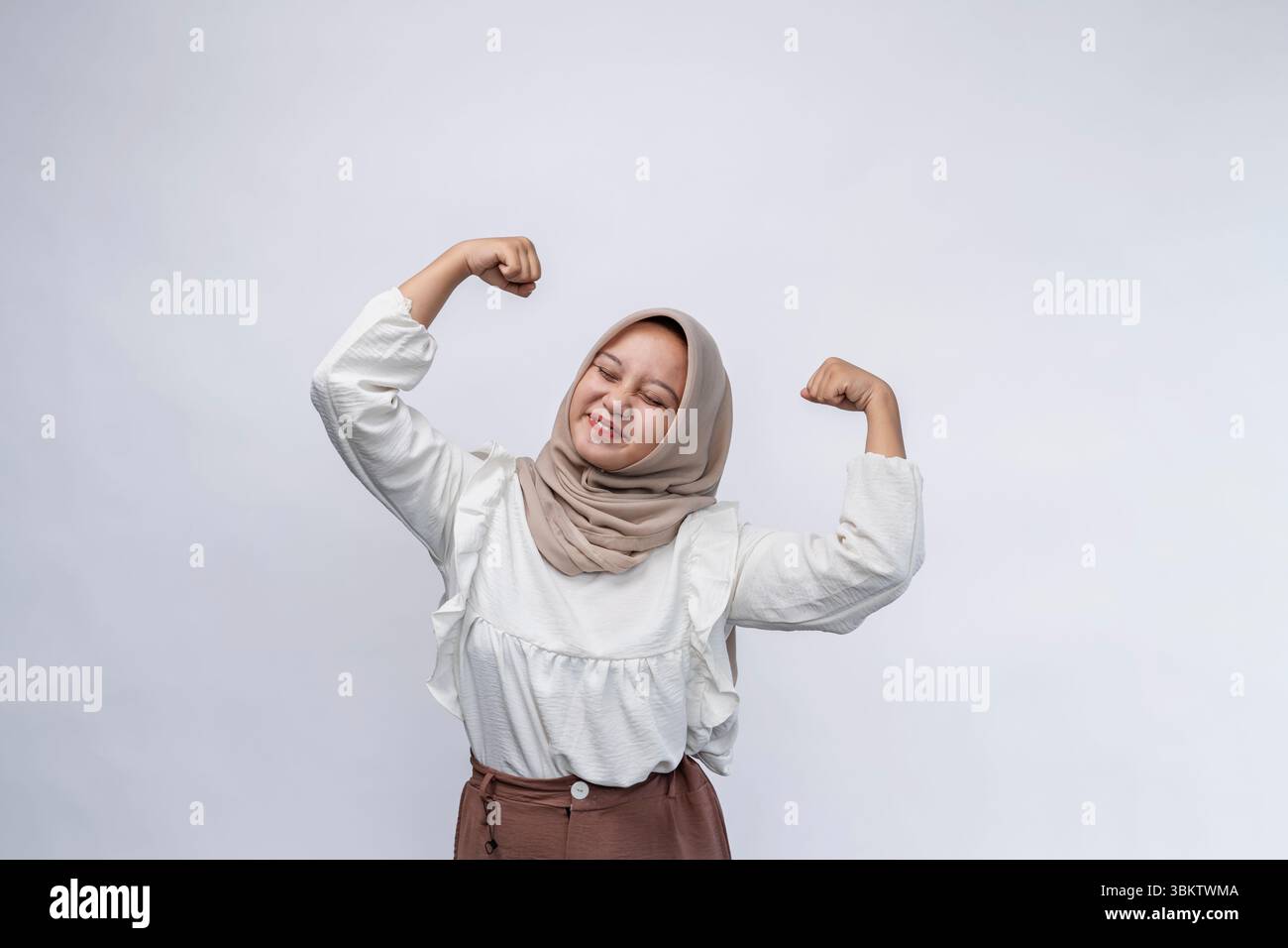 Excited beautiful Indonesian Muslim woman wearing hijab celebrating ...