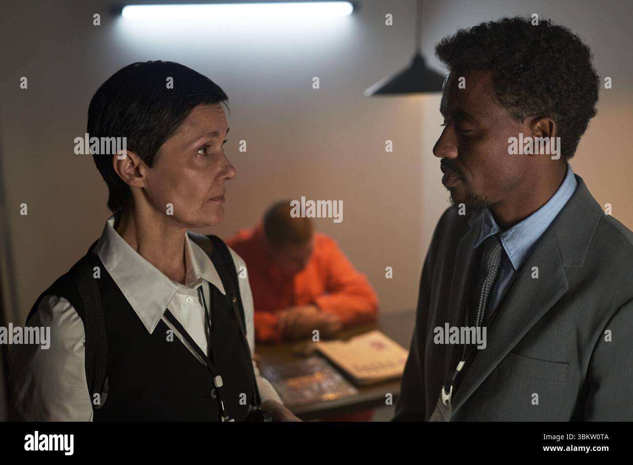 Middle aged Caucasian woman and middle aged Black man standing, talking ...