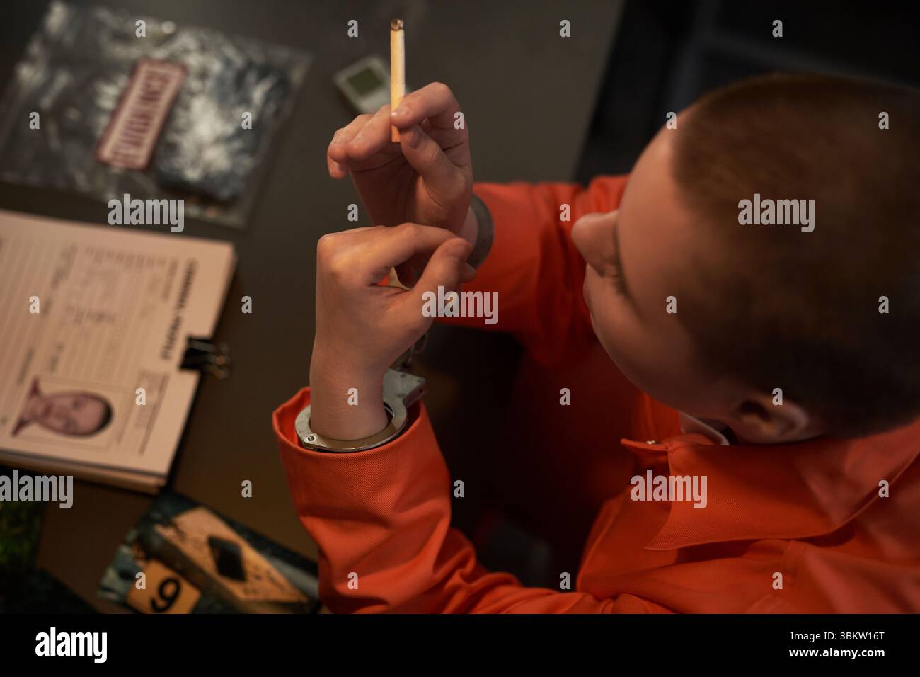 Young adult Caucasian woman with shaved head sitting handcuffed at ...