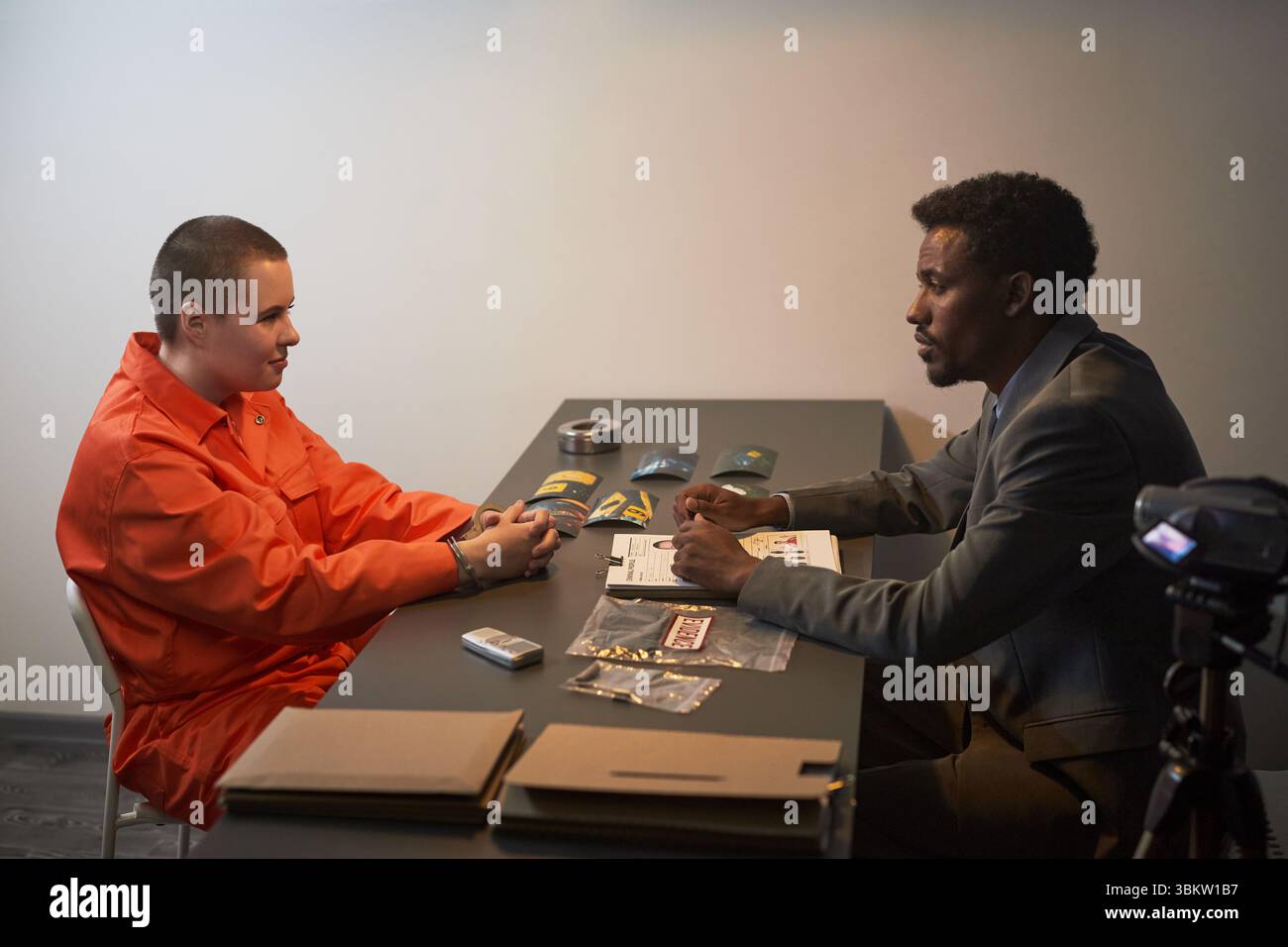 Caucasian teenager with shaved head wearing orange prison uniform ...