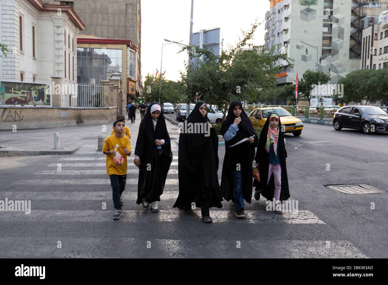 Tehran, Tehran, Iran. 22nd June, 2025. people walk down the street, one ...