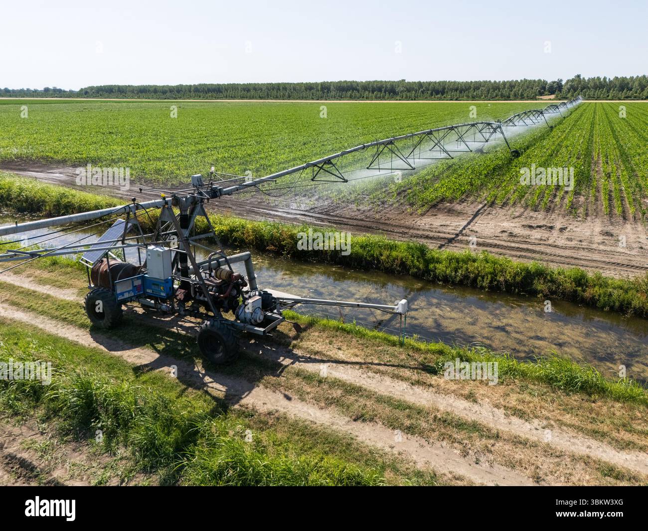 Autonomous machine is moving watering pivot along irrigation canal ...