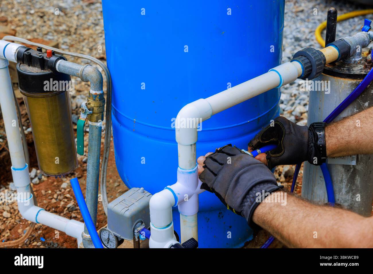 Skilled worker repairs artesian water well unit using tools materials ...