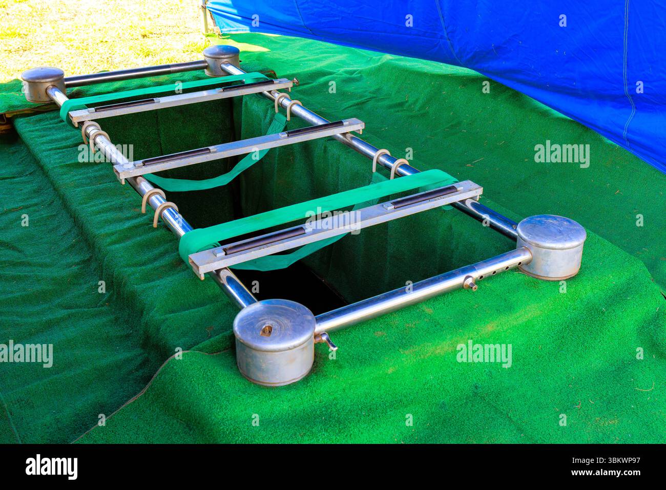 During burial ceremony, silver coffin holder is placed over freshly dug ...