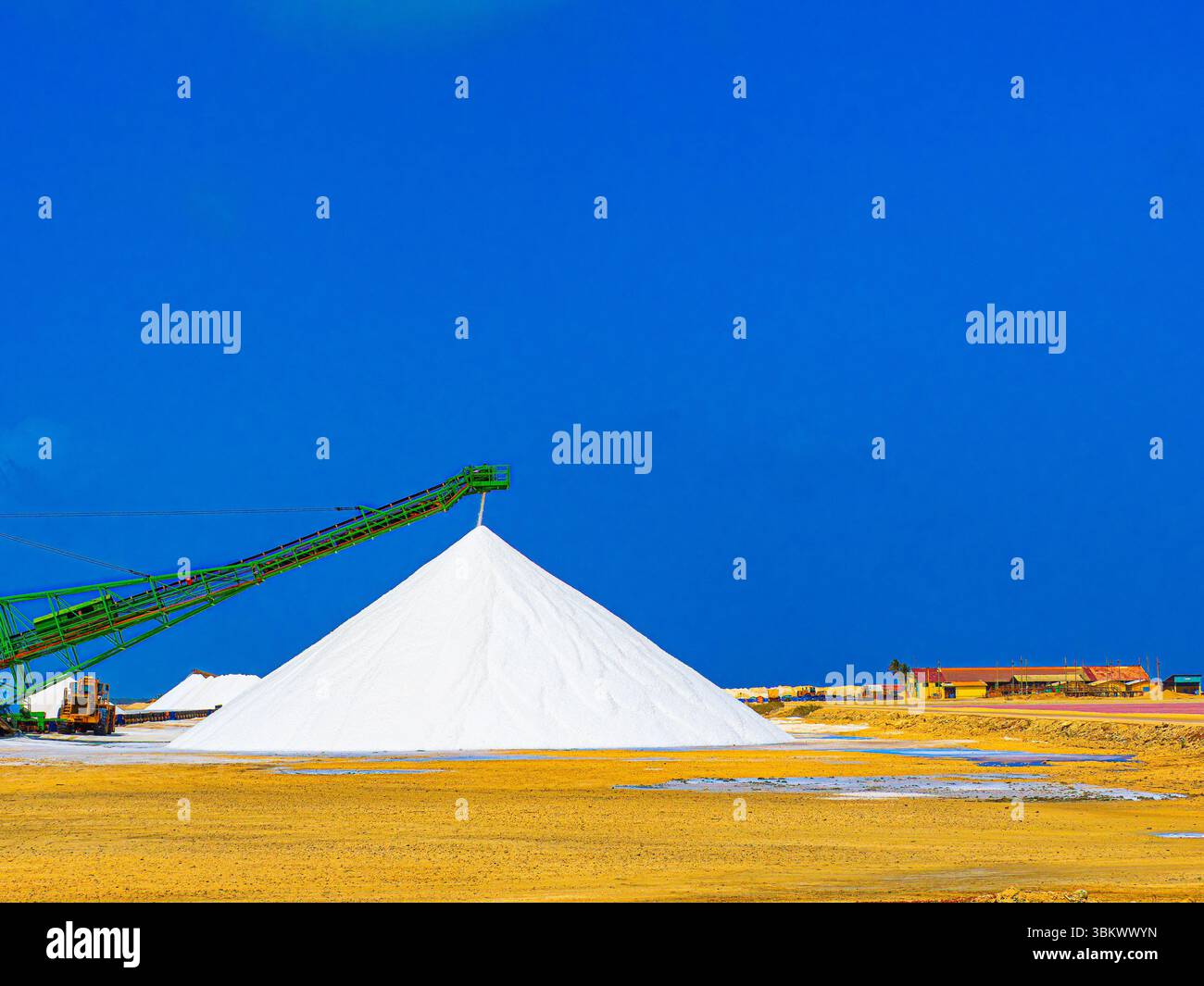 White salt hills and vibrant red water in the sea salt mines of Bonaire ...