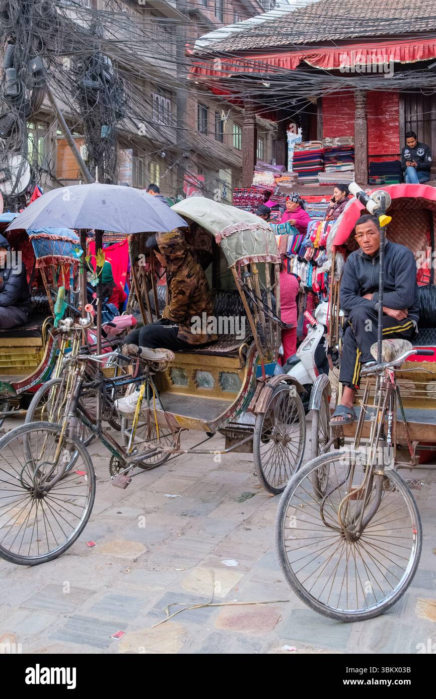 Rickshaw drivers wait for fares on a busy market street Stock Photo - Alamy