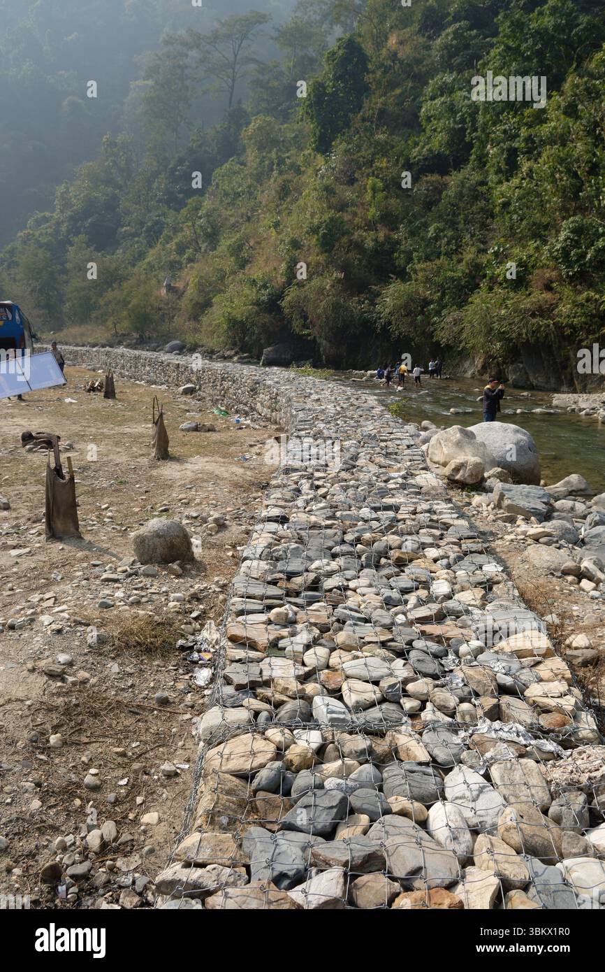 Riverbank protection: A gabion wall is built. People are in the river ...