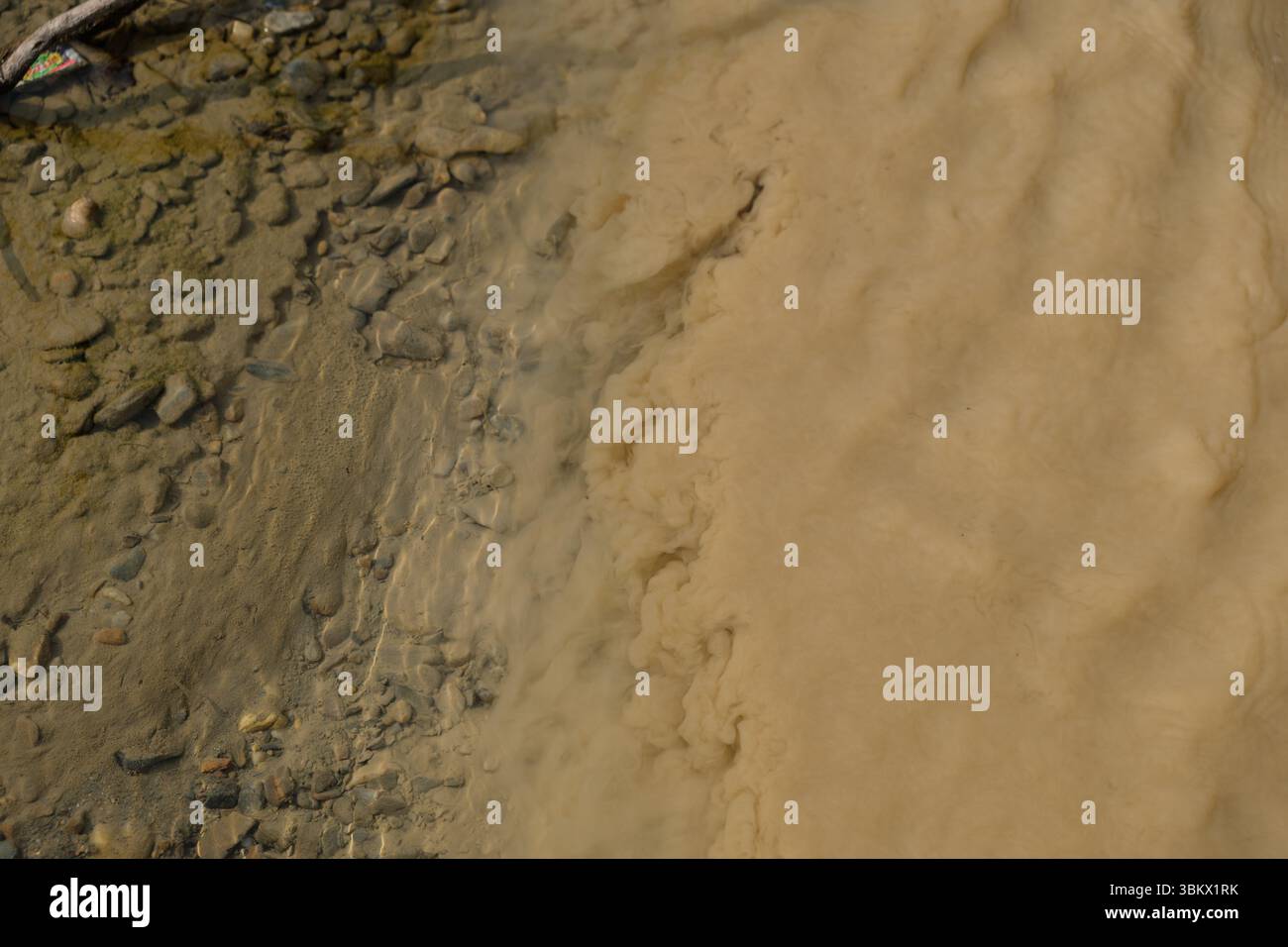 Nature's flow: Clear water meets muddy sediment Stock Photo - Alamy