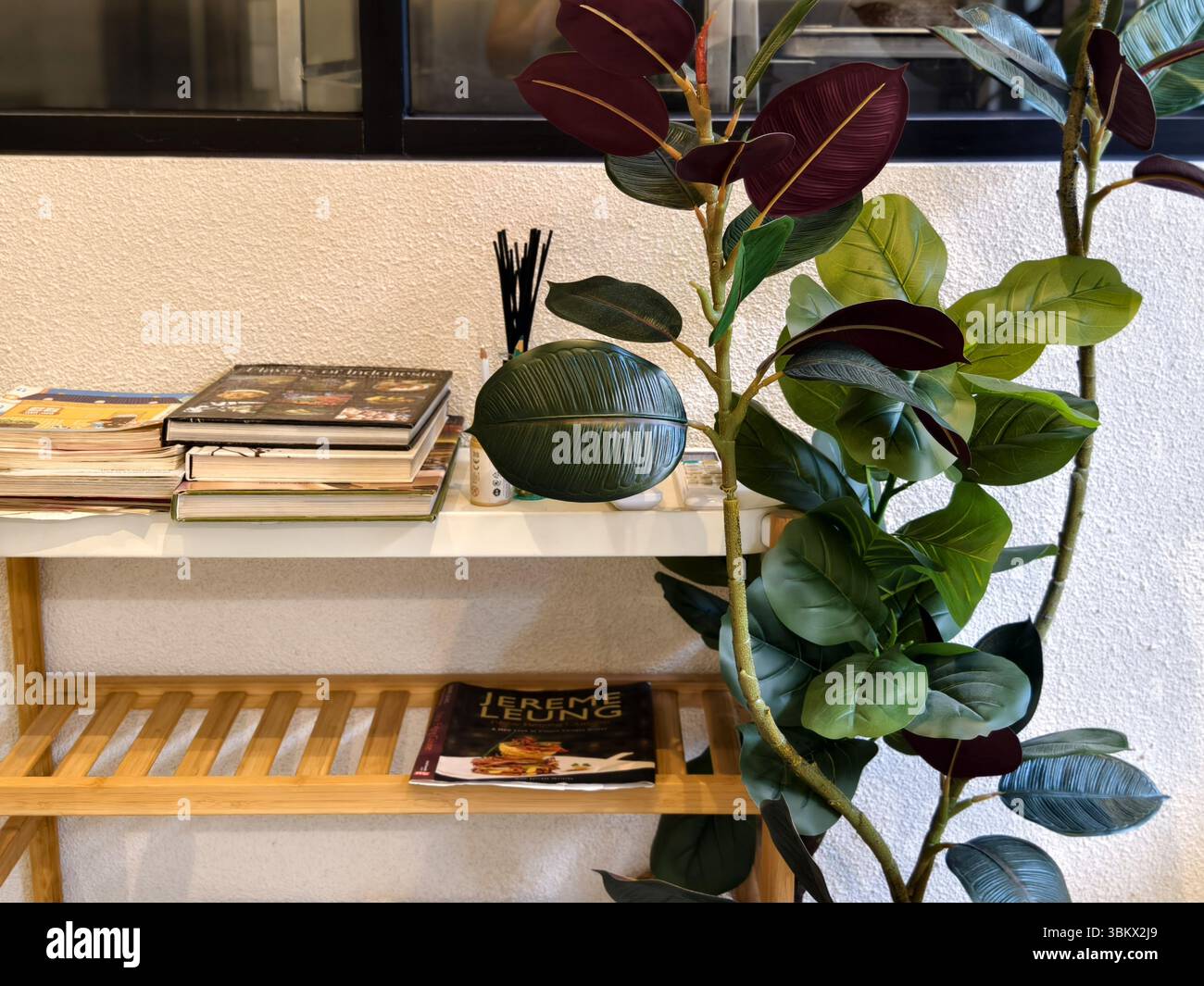 A reading nook setup featuringA small bookshelf with stacked magazines ...