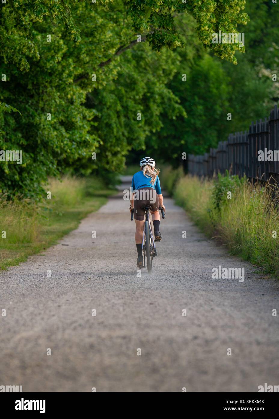 Woman cyclist training along gravel hi-res stock photography and images ...