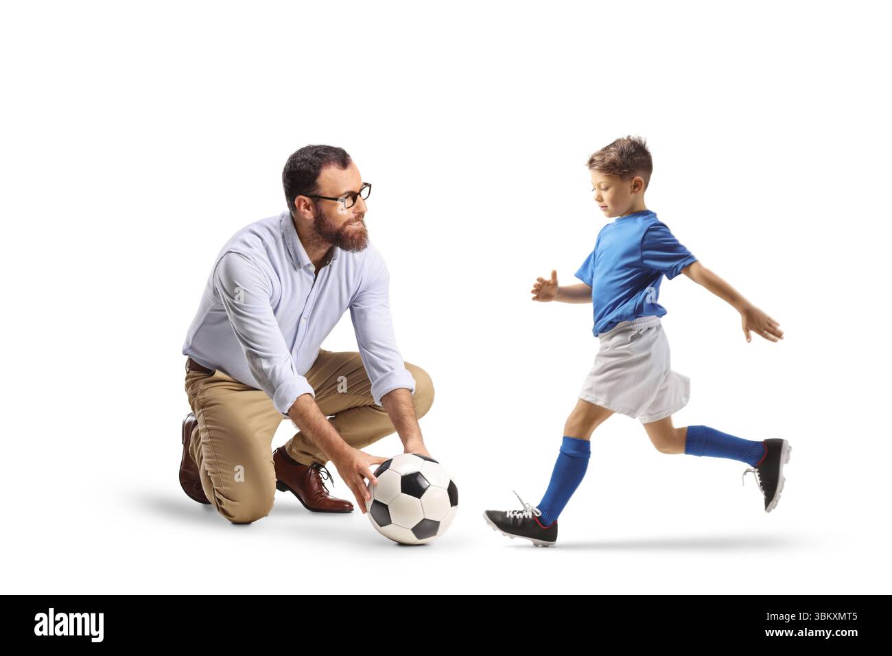 Father holding a football and boy kicking the ball isolated on white ...